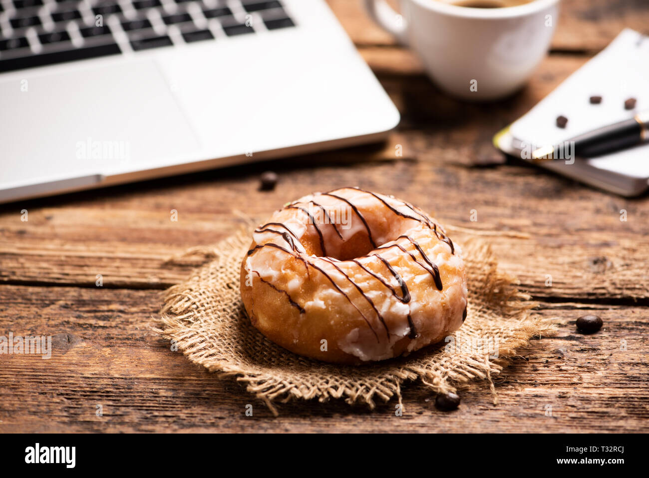 Donuts on working office desk Stock Photo - Alamy