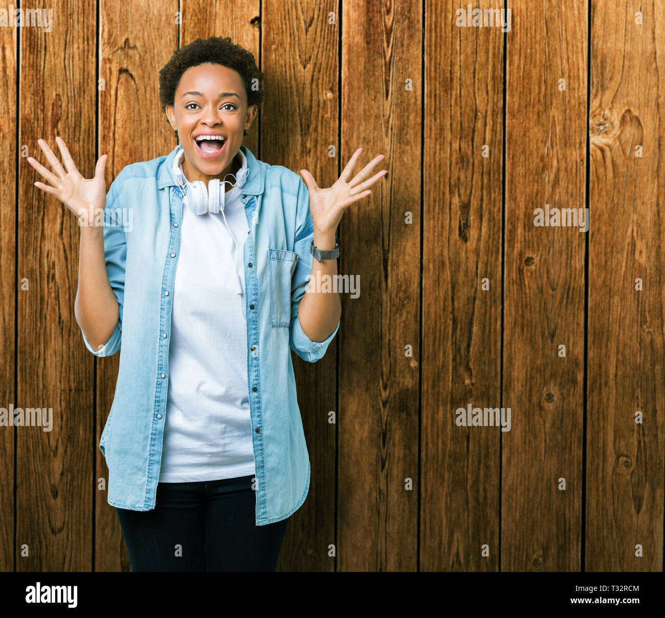 Young african american woman wearing headphones over isolated ...