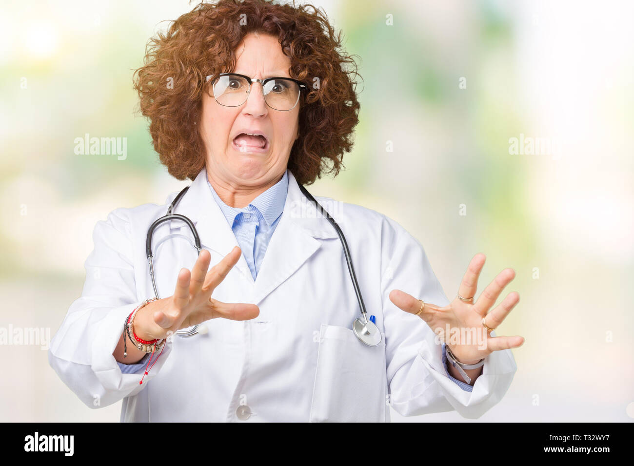 Middle ager senior doctor woman over isolated background afraid and ...