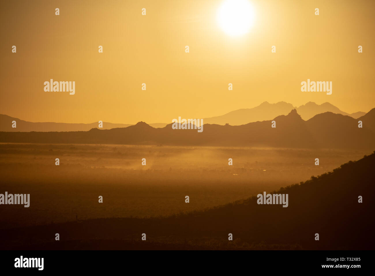 The sun rising over the mountains of the Arizona desert with natural ...