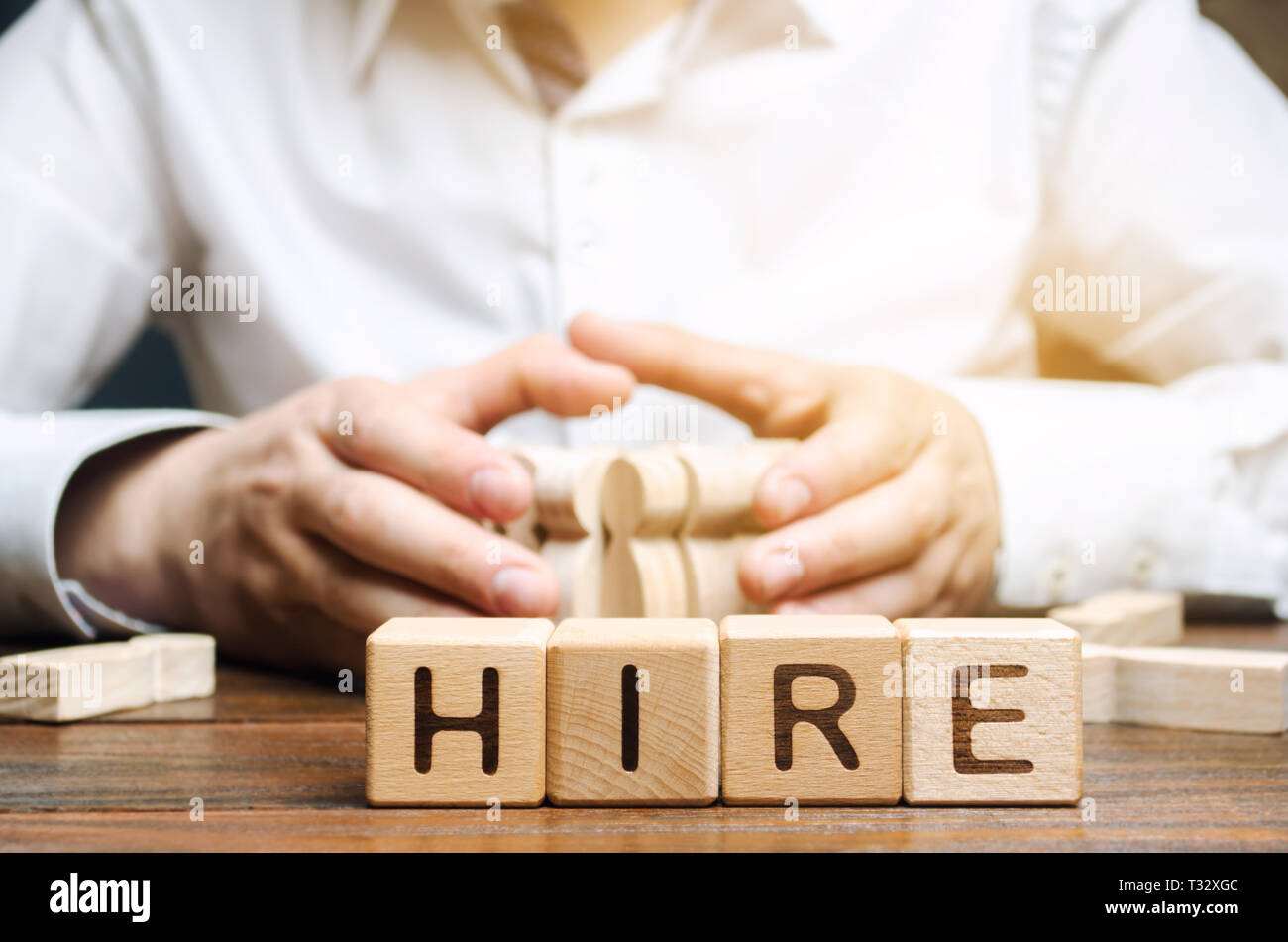 Wooden blocks with the word Hire. Headhunter selects a person from the ...