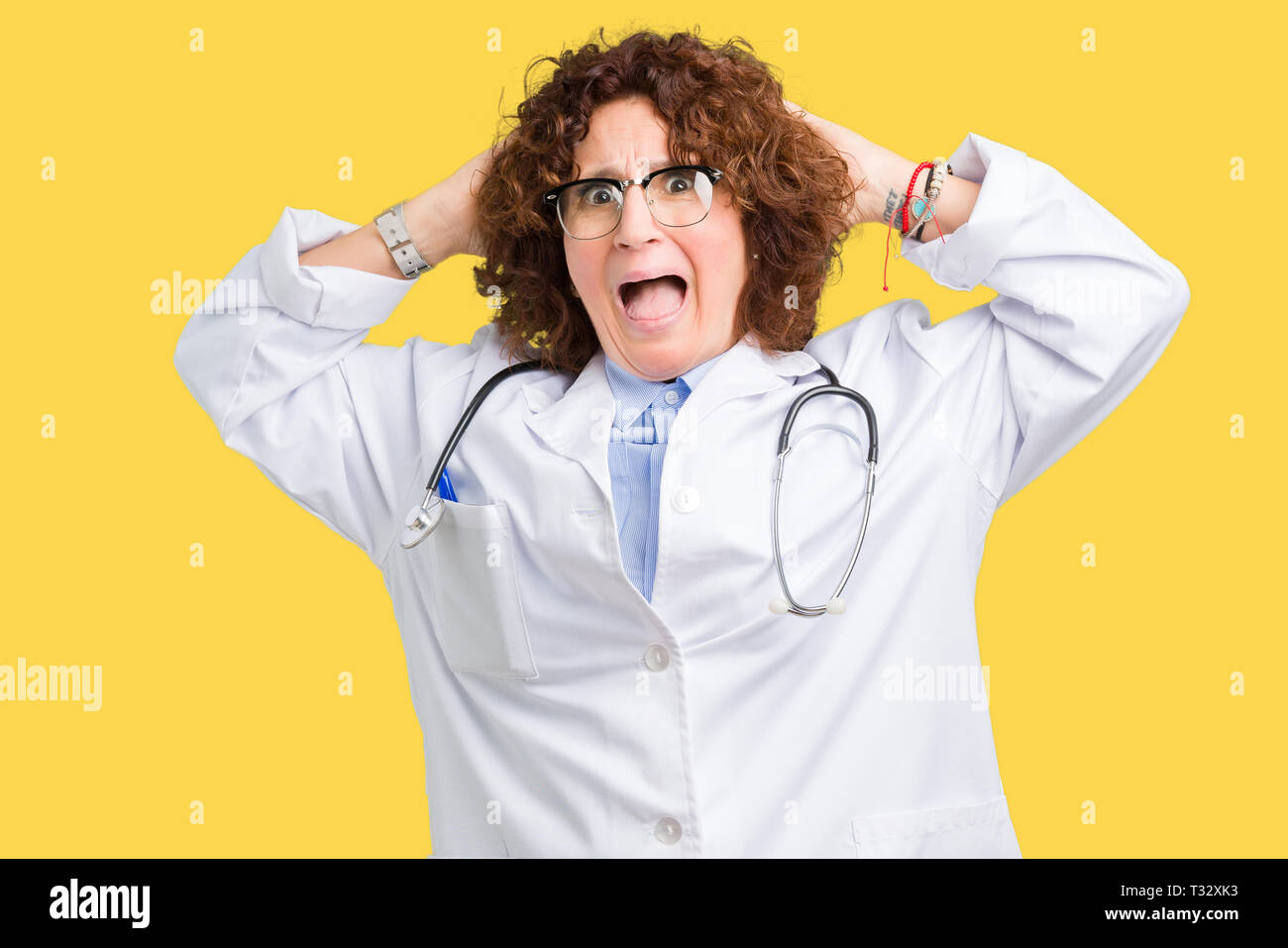 Middle ager senior doctor woman over isolated background Crazy and ...