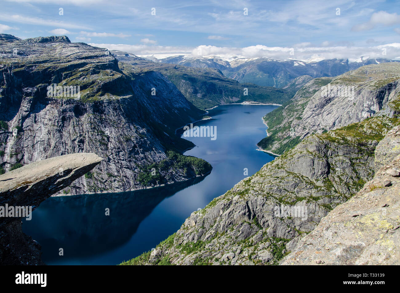 Spectacular view of Trolltunga rock with a blue lake 700 meters lower ...