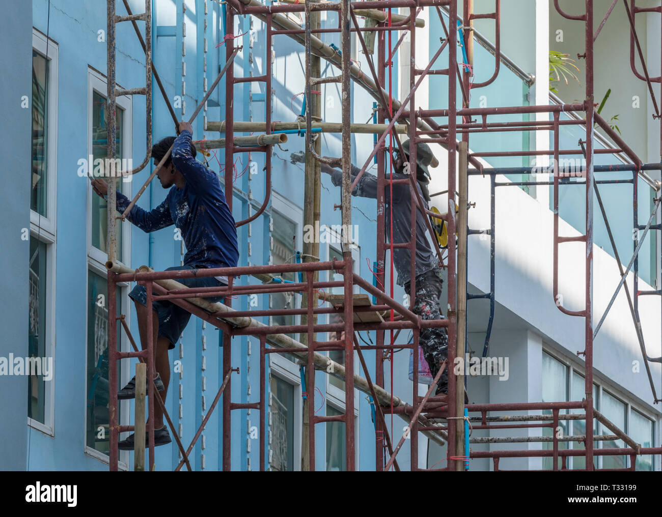 Scaffolders working on a bamboo or unsteady unstable tall high scaffold ...