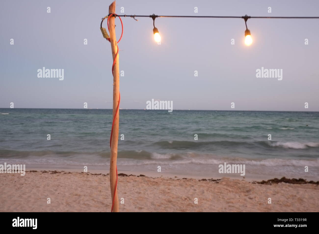 Seafront restaurant. Beach illuminated by makeshift light fixtures ...