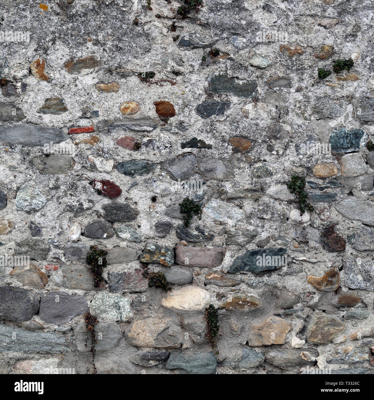 Wall made of colorful rocks, tiles and concrete. Beautiful grey ...