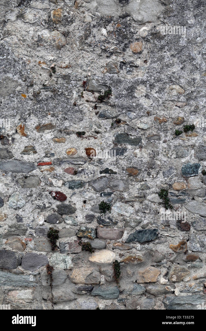 Wall made of colorful rocks, tiles and concrete. Beautiful grey ...