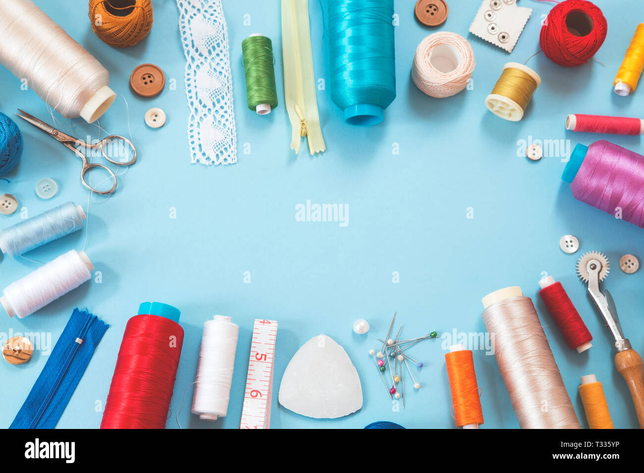 Various sewing items on blue background Stock Photo - Alamy
