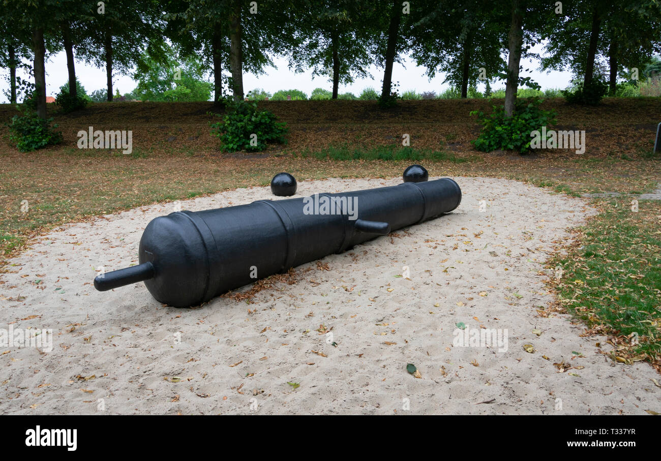 the barrel of an old cannon with two cannon balls in the background ...