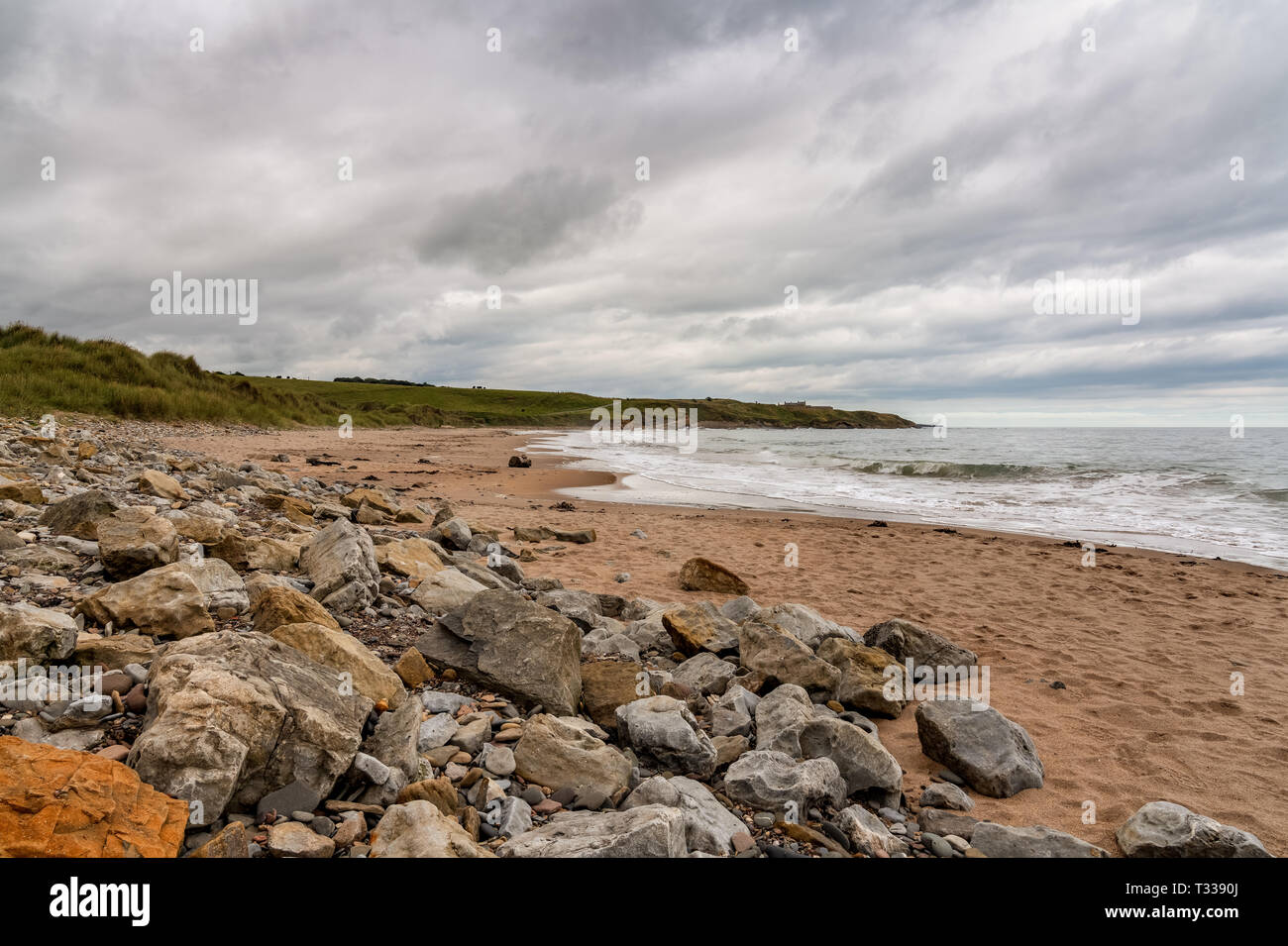 Dark clouds and large stones, seen at Cocklawburn Beach near Berwick ...