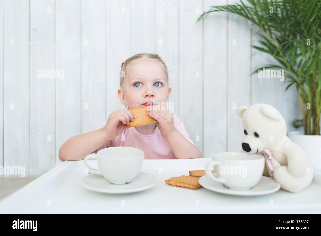 Cute little girl drinks tea with her teddy bear Stock Photo - Alamy