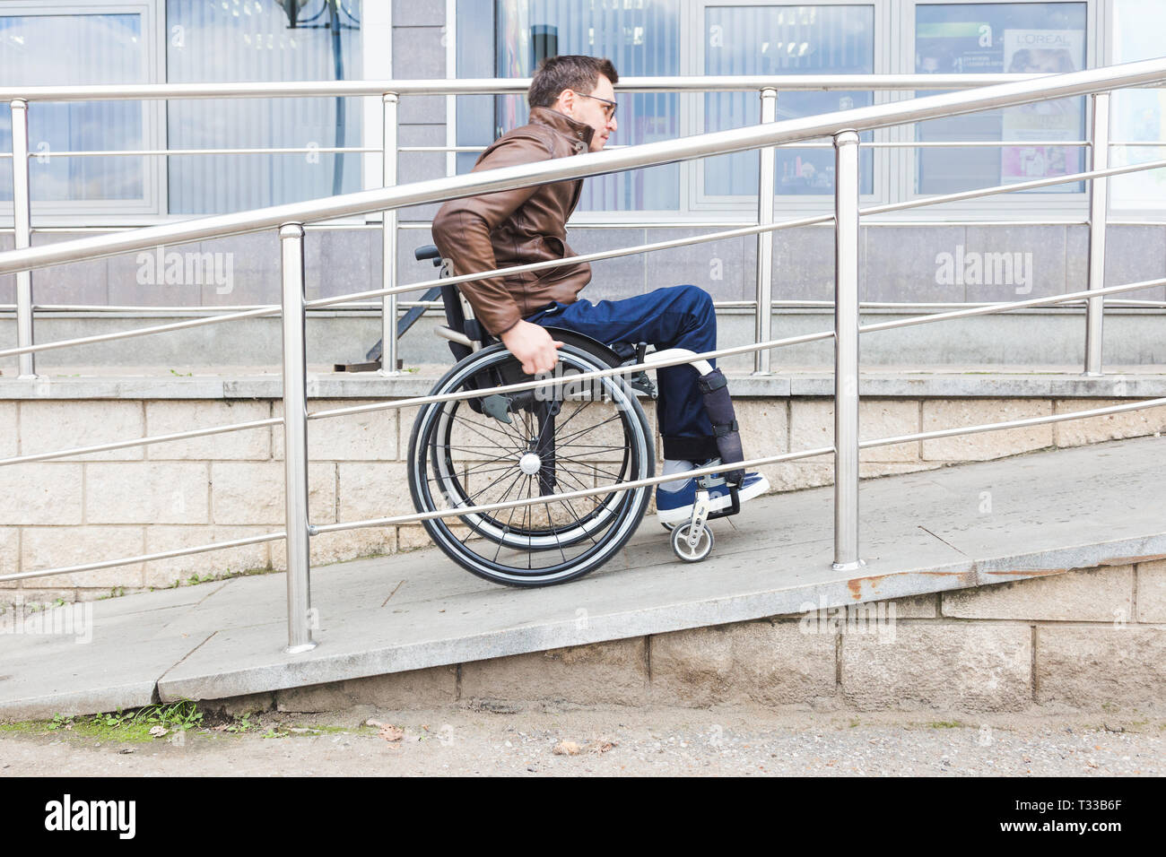 Man in a wheelchair use a wheelchair ramp Stock Photo - Alamy
