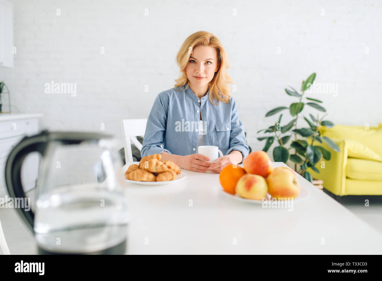 Happy woman cooking breakfast on the kitchen. Female person at home in ...