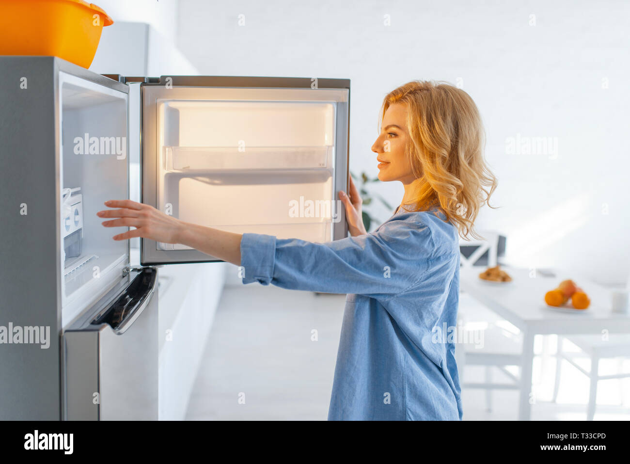 Young woman opened the fridge on the kitchen. Female person cooking ...