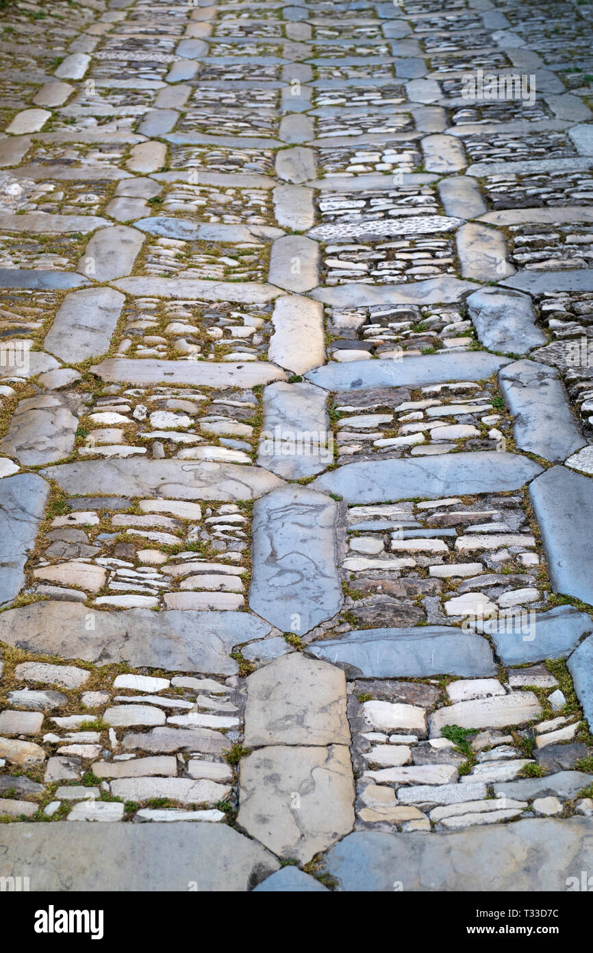 Patterns on the ground in pastel colours in cobble stones alleyway in ...