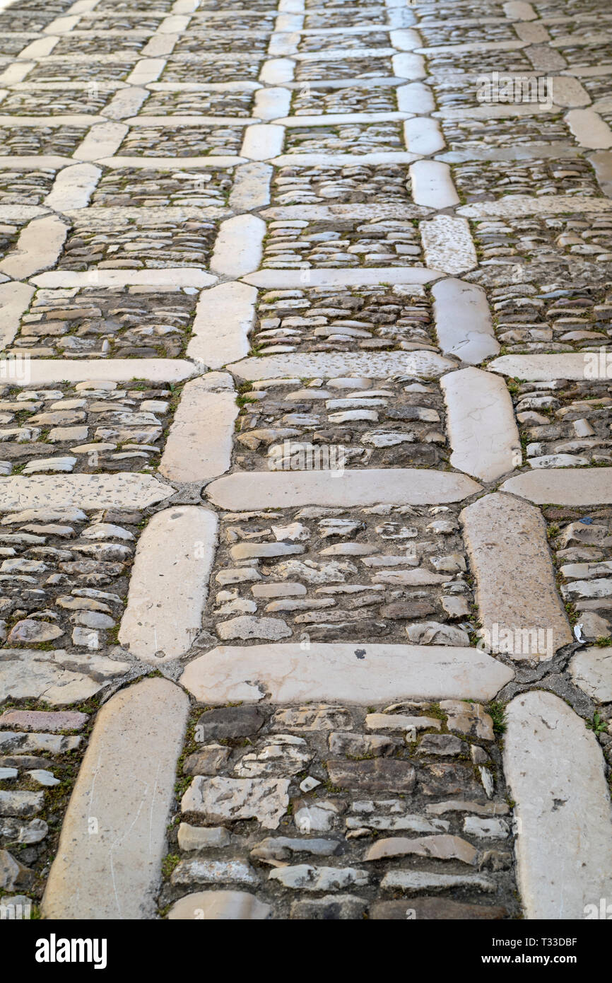 Patterns on the ground in pastel colours in cobble stones alleyway in ...
