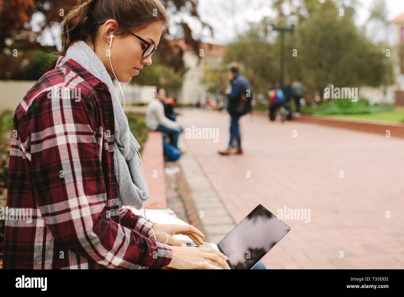 Side view of young university student working on laptop. Female college ...