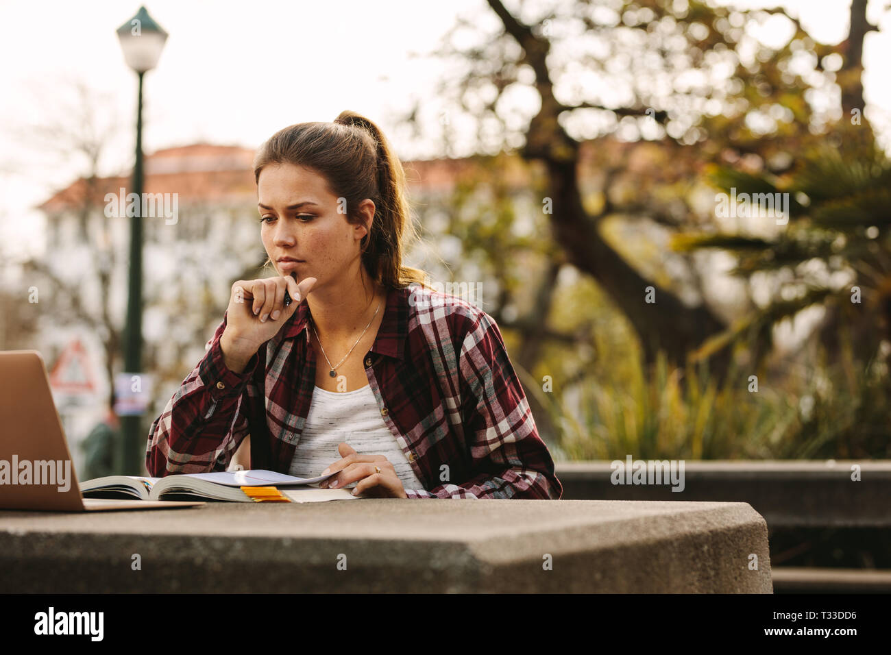 Female student studying at university campus searching information on ...