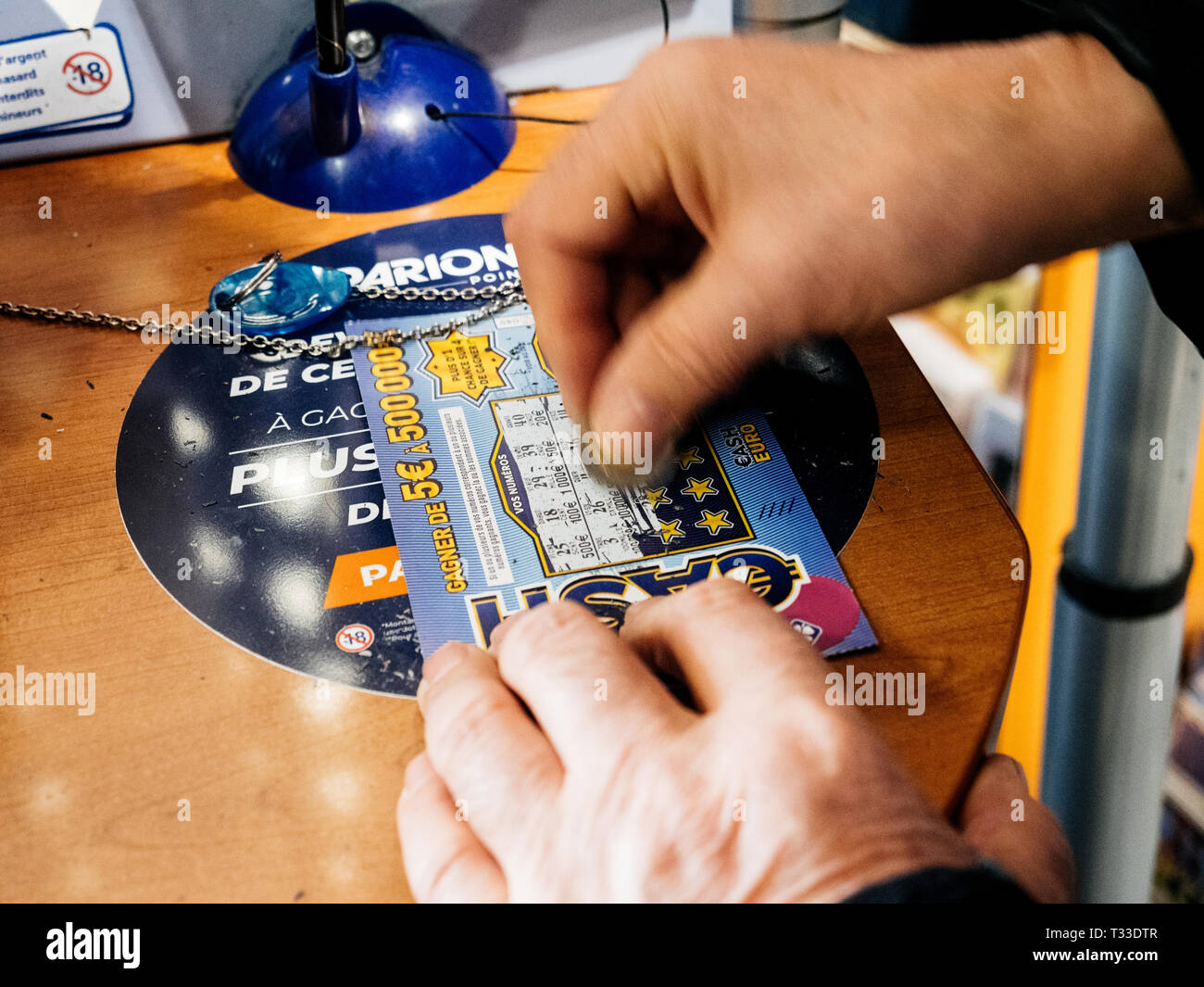 Paris, France - 29 Mar 2019: Senior male hands scratching lottery ...