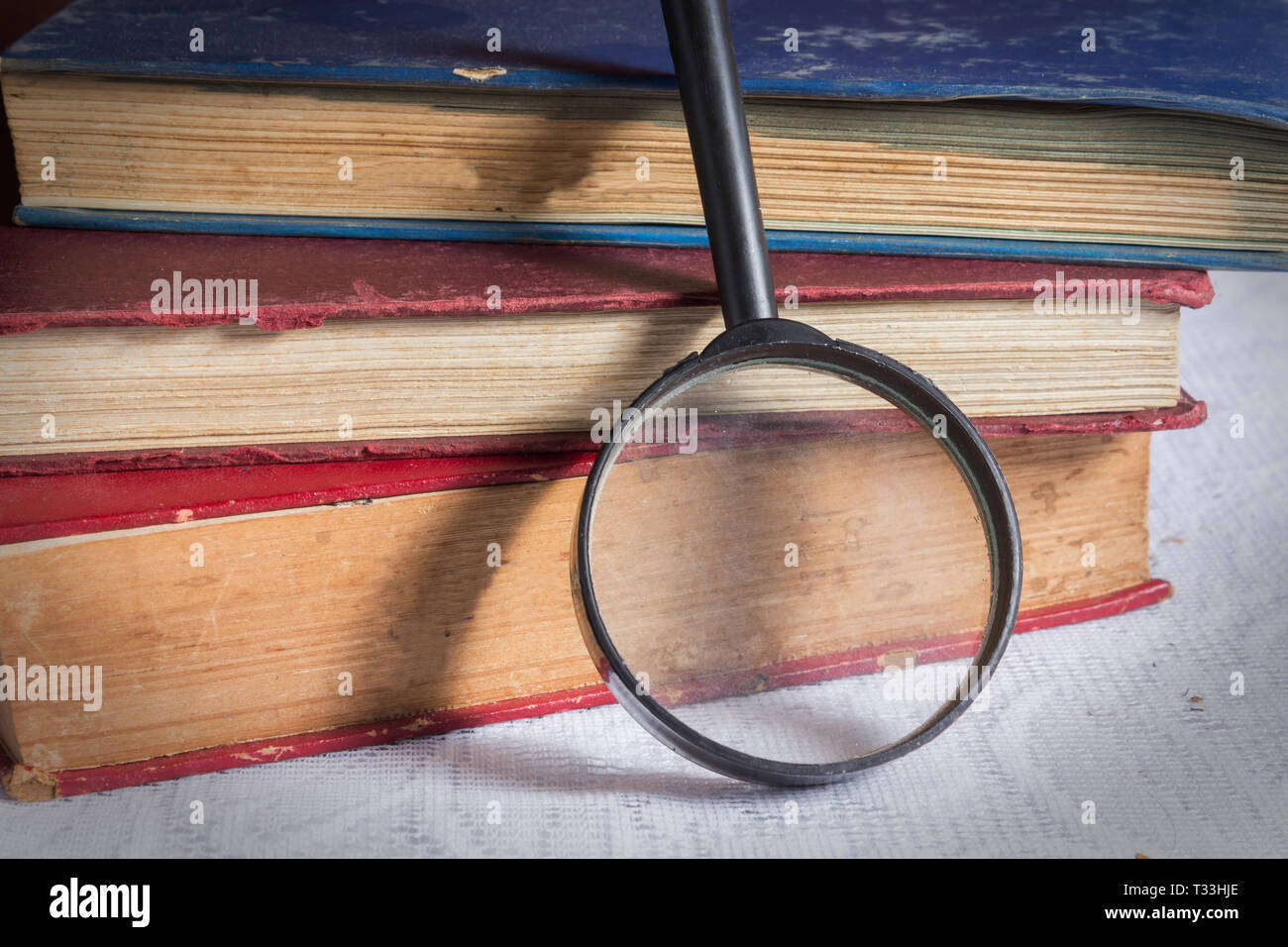 Magnifier with books,education concept Stock Photo - Alamy