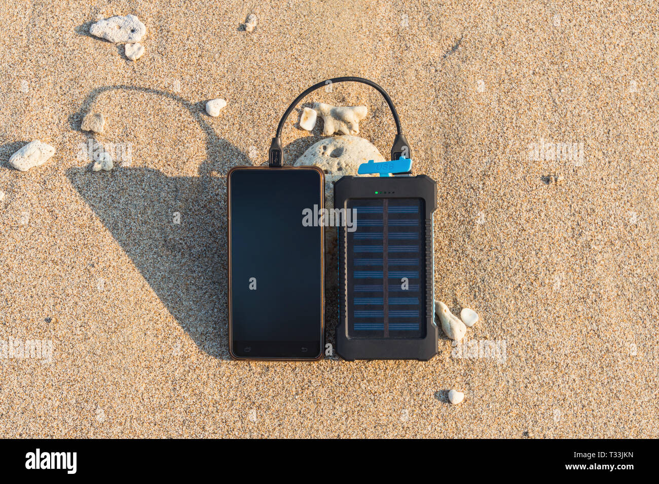 Portable solar panel is on the beach in the sand and charges the ...