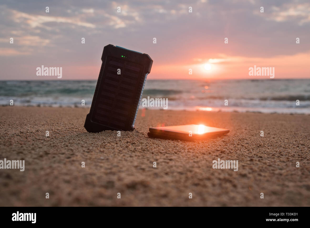 Portable solar panel is on the beach in the sand and charges the ...