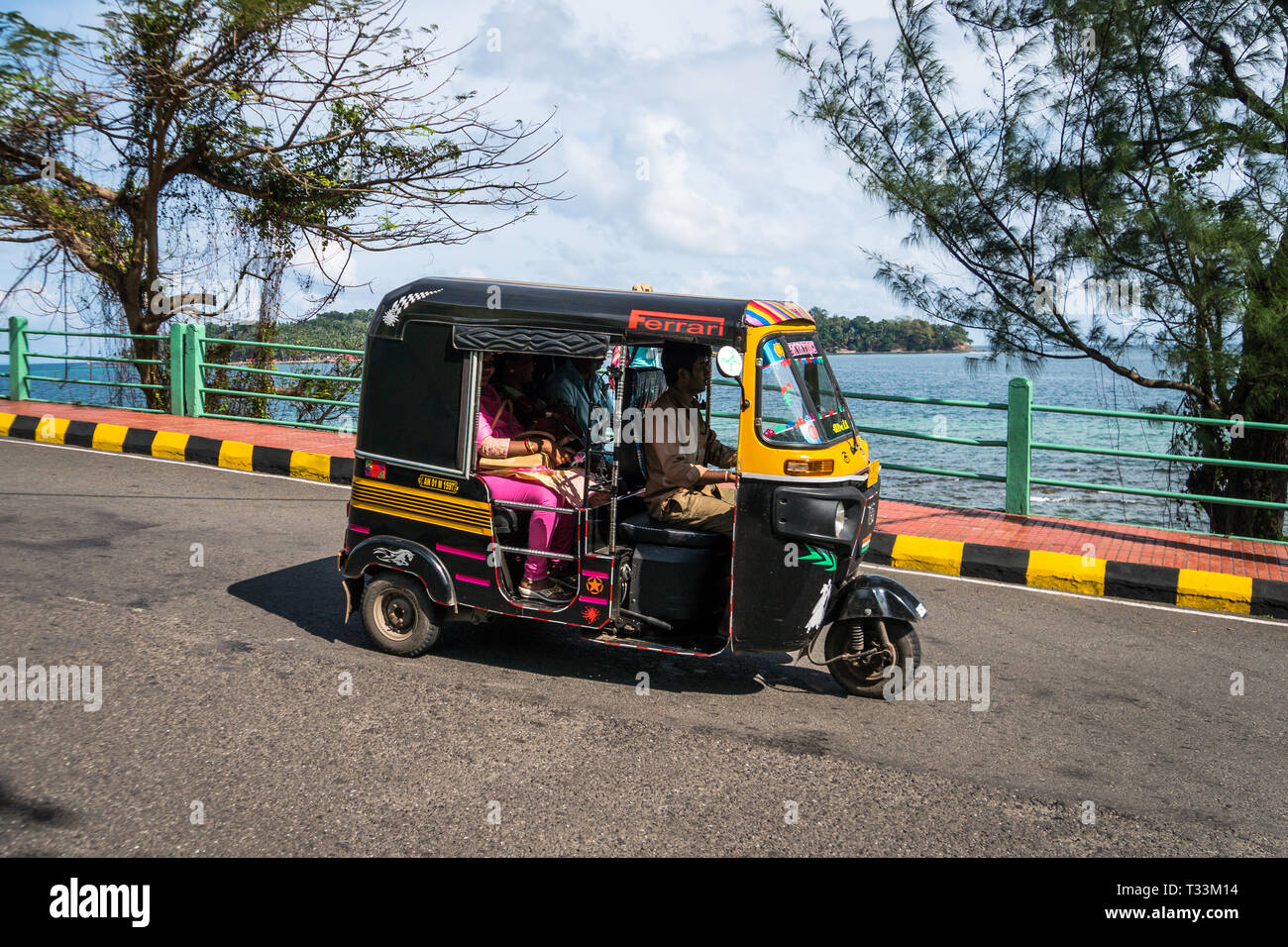 auto rickshaw, Otto, carries passengers on the road against the sea ...