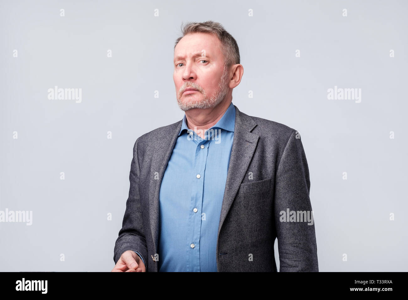 Self confident senior man posing in studio staring at camera with ...