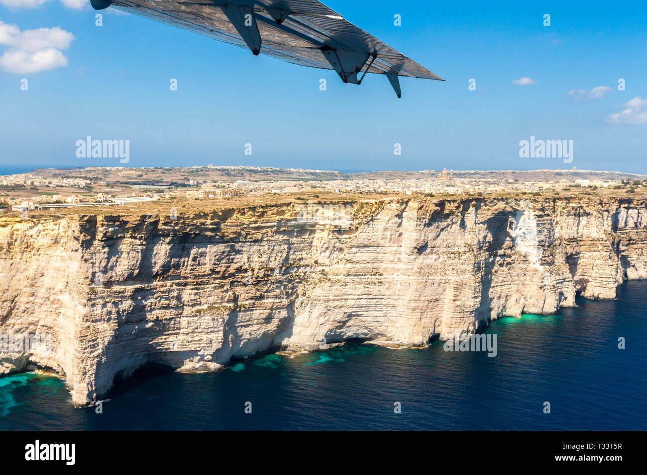 Gozo island from above, under the wing of a small plane. Aerial view of ...