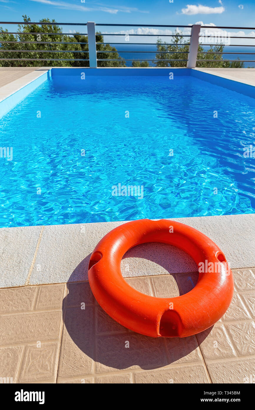 Orange life buoy lies at blue greek swimming pool near coast Stock ...
