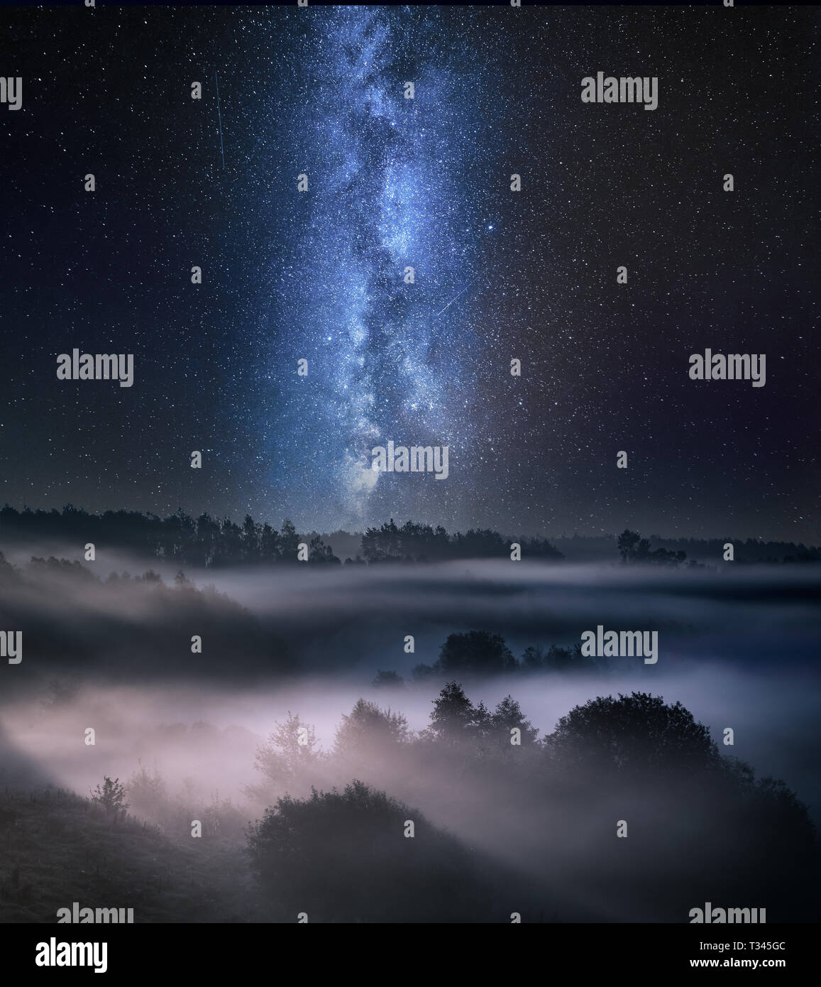 Wonderful foggy valley at night with milky way Stock Photo - Alamy