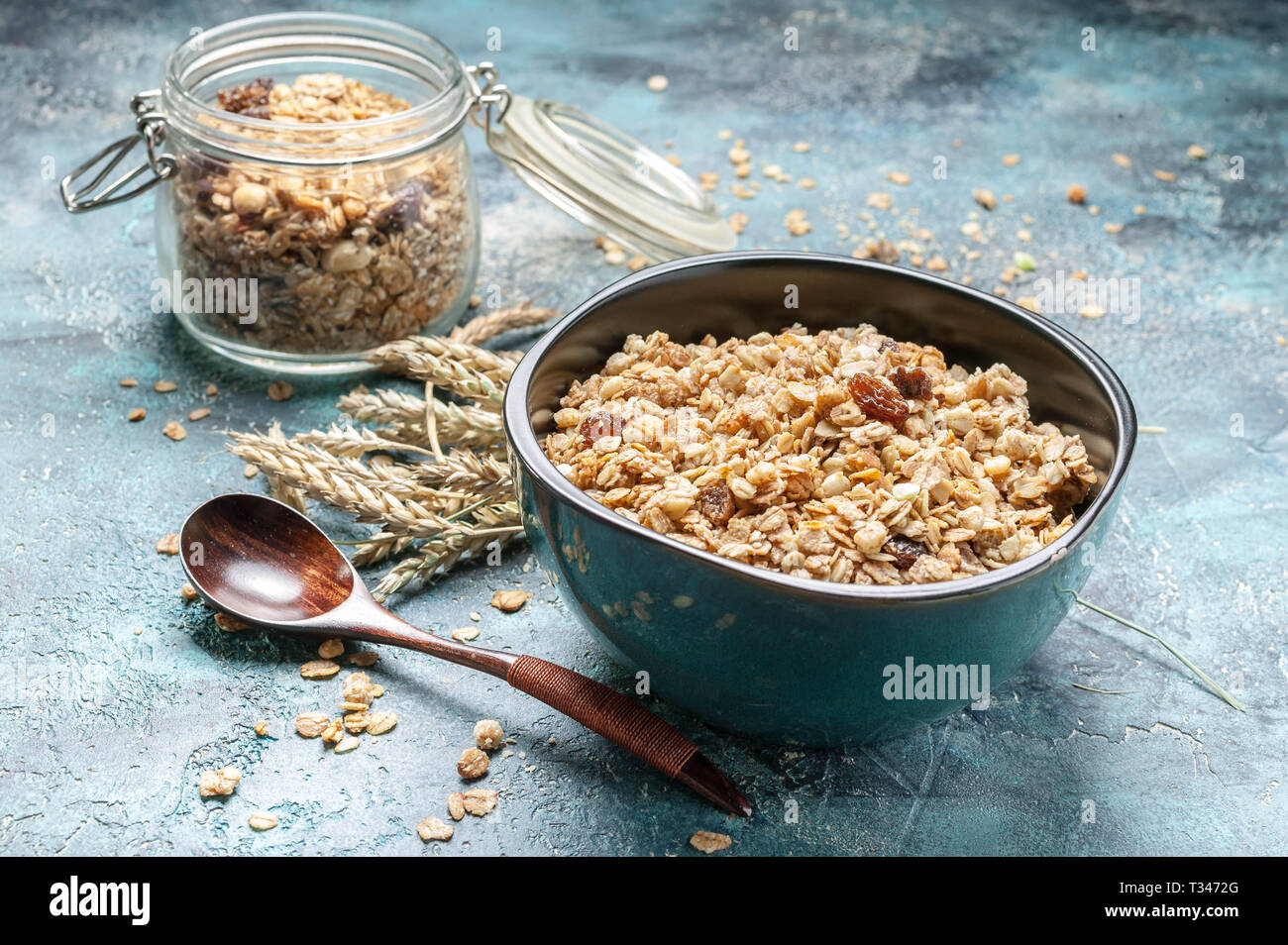 Homemade granola with nuts in a blue glass bowl. Morning light from the ...
