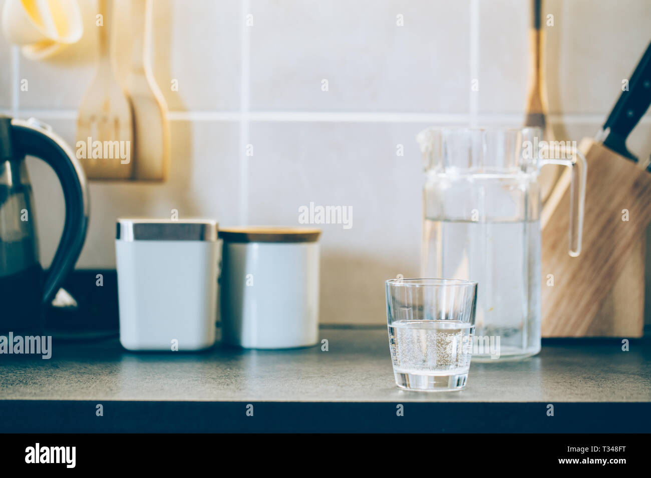 Glass of pure water and jar on kitchen table Stock Photo - Alamy