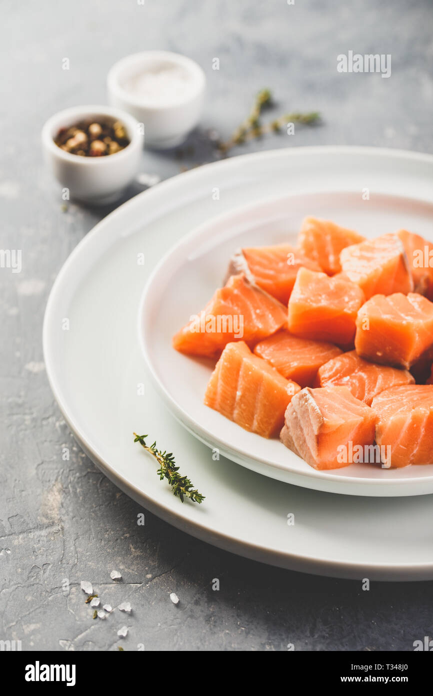 Diced pieces of salmon for marinating on white plate Stock Photo - Alamy