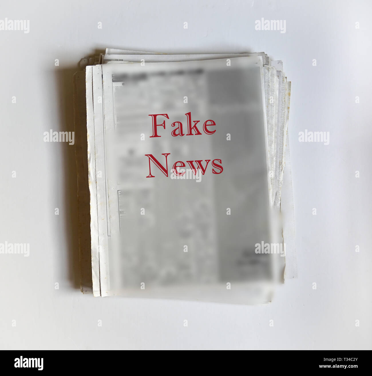 Fake news concept - words in red on top of a stack of newspapers Stock ...