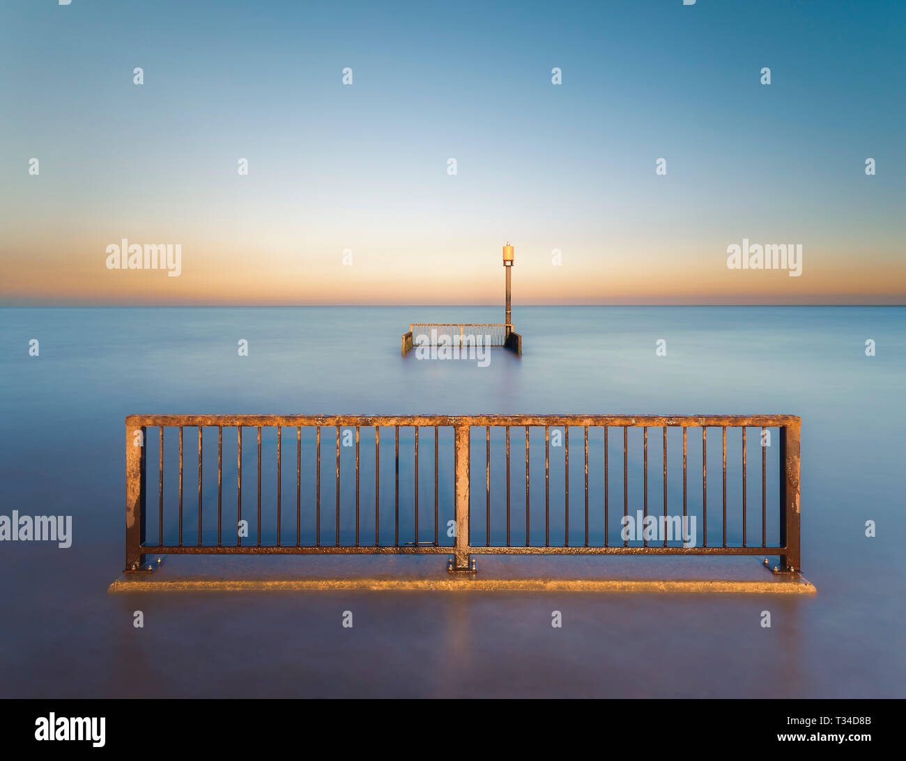 Two metal railings in the sea at high tide Stock Photo - Alamy