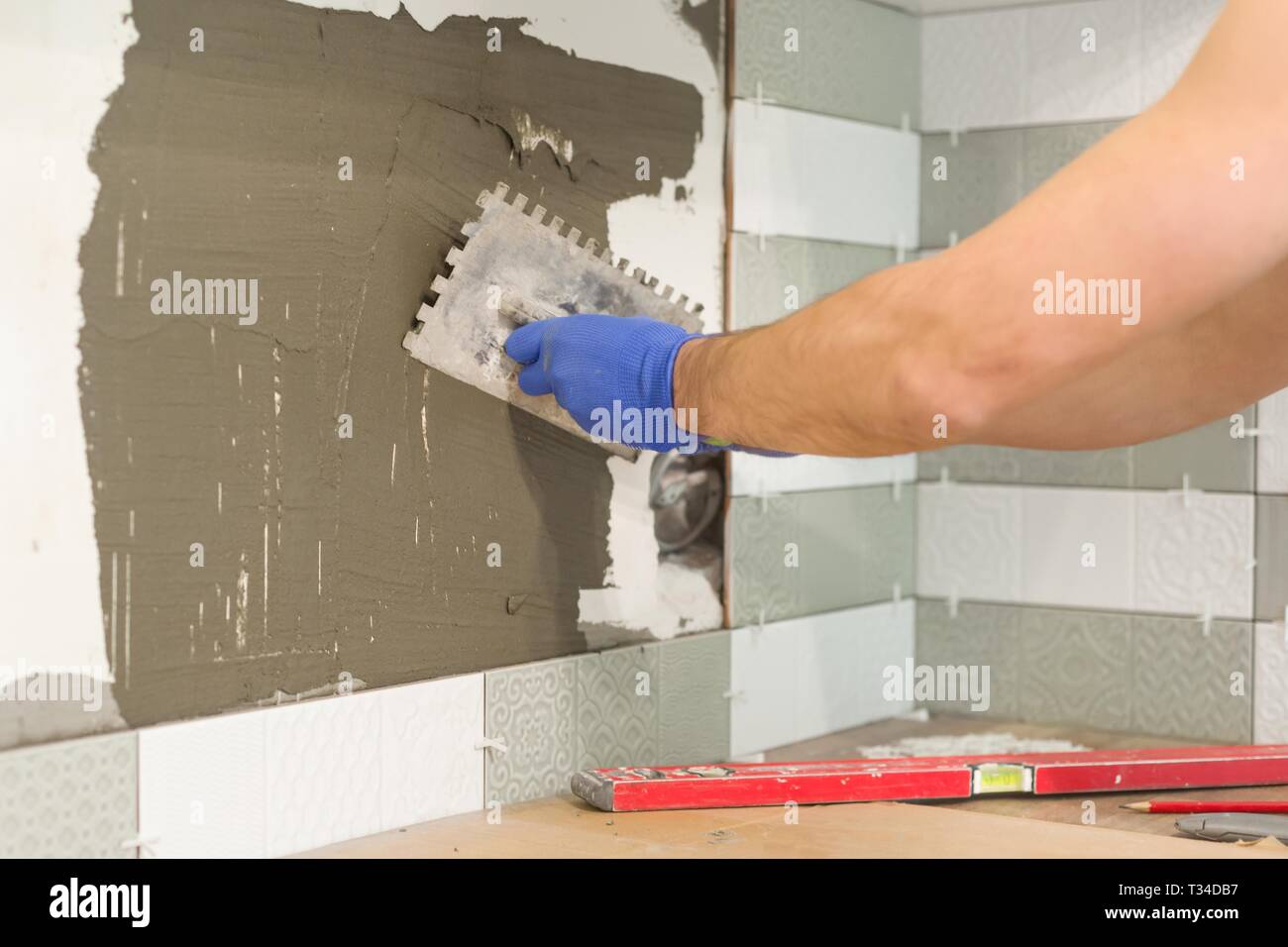 Repair and construction of the kitchen, hands of tiler installing ...