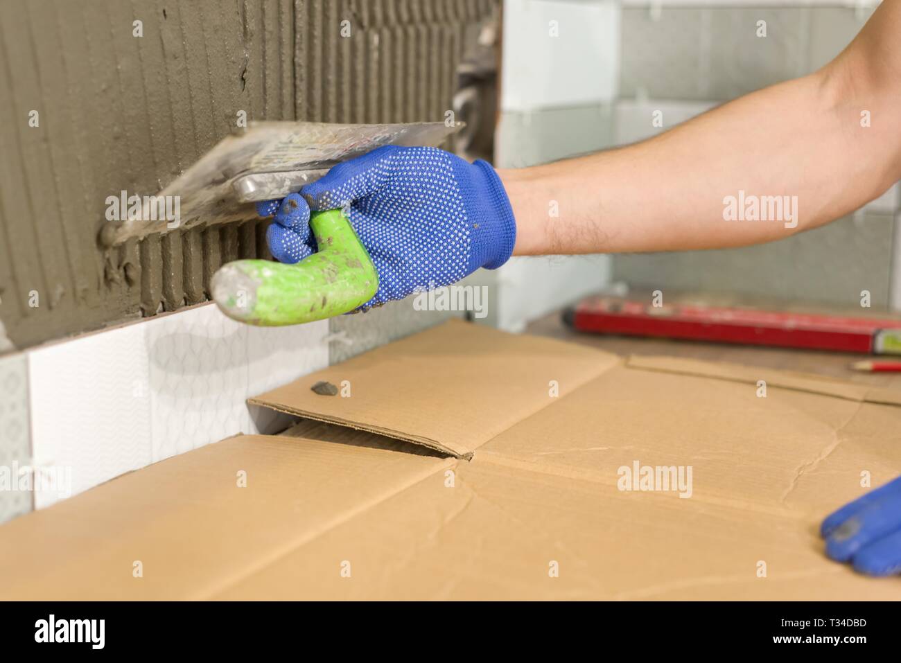 Repair and construction of the kitchen, hands of tiler installing ...