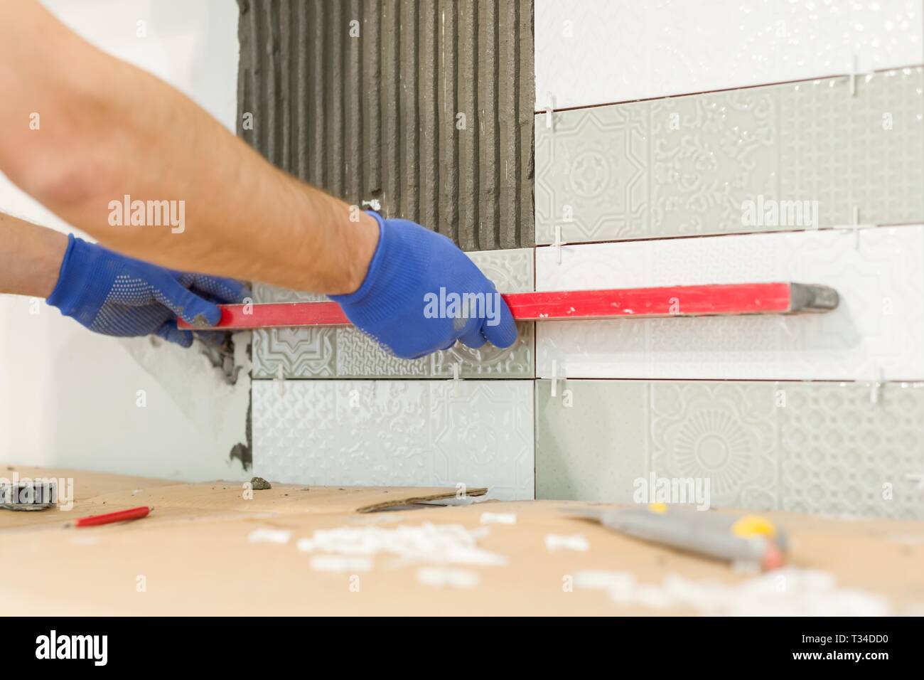 Repair and construction of the kitchen, hands of tiler installing ...