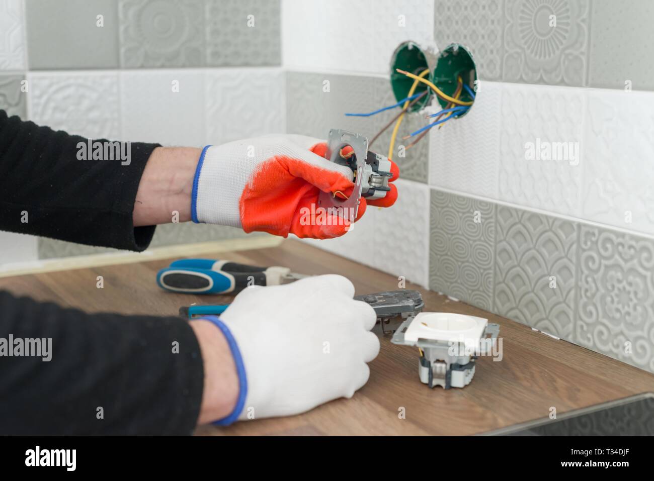 Renovation and construction in kitchen, close-up of electricians hand ...