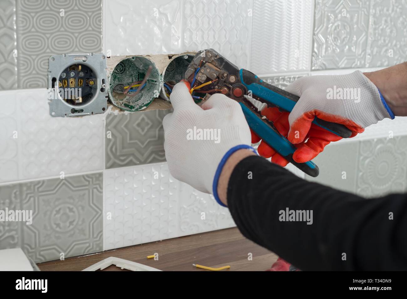 Renovation and construction in kitchen, close-up of electricians hand ...