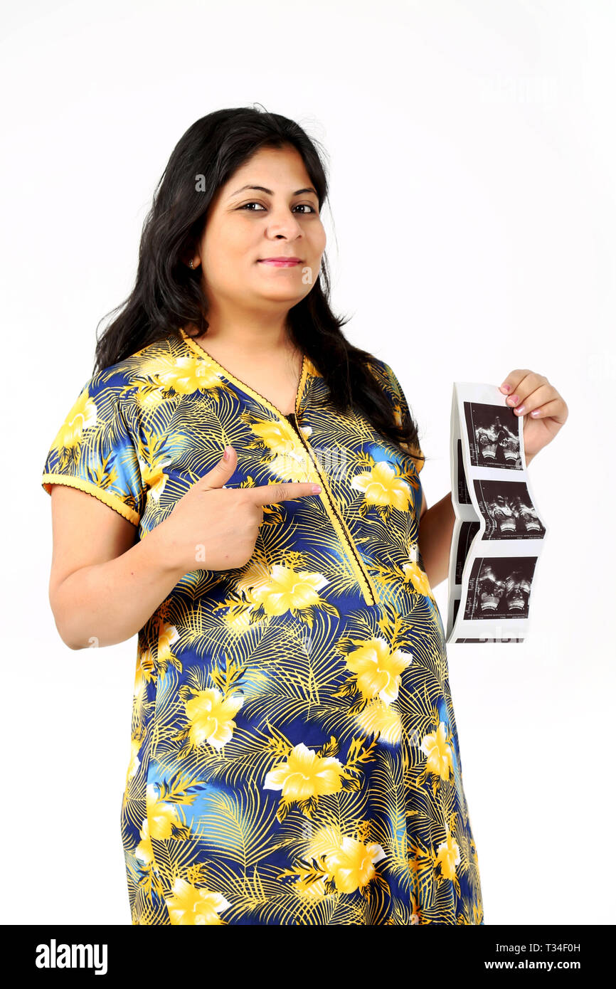 Photo Of pregnant lady is holding baby ultrasound in hand with smile ...