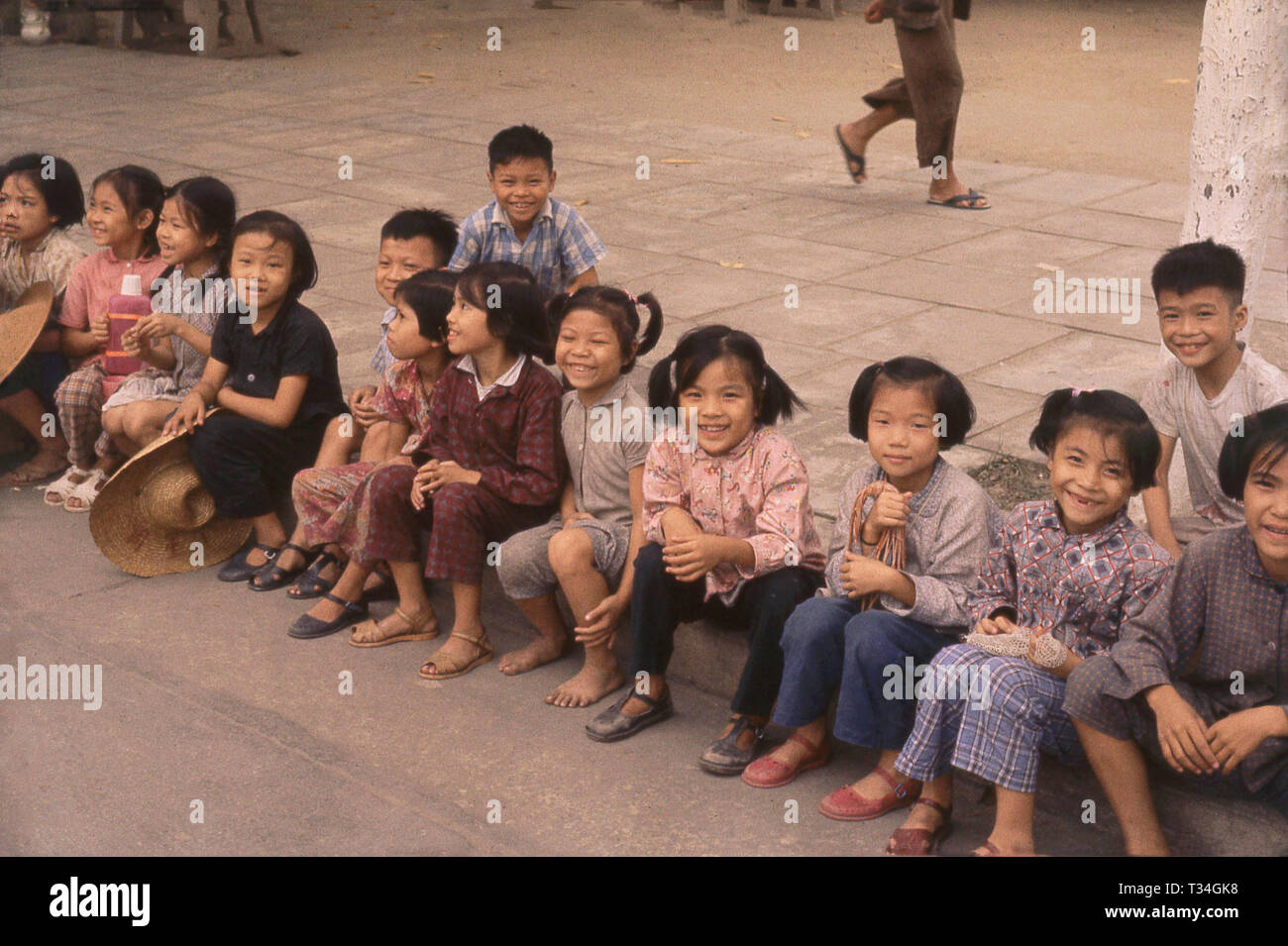 1960s, historical, group of happy chinese children sitting in a line ...