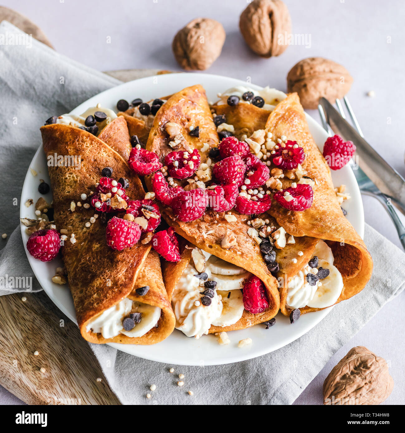 Pumpkin crepes with whipped cream, banana, nuts and raspberries Stock ...