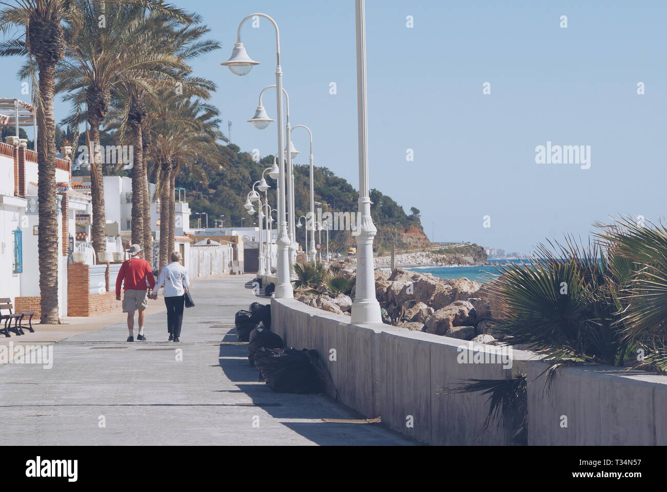 Senior couple walking along a beach promenade, Malaga, Spain Stock ...