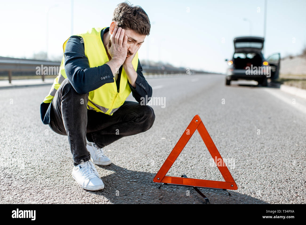 Man with despair emotions sitting near the emergency sign on the ...