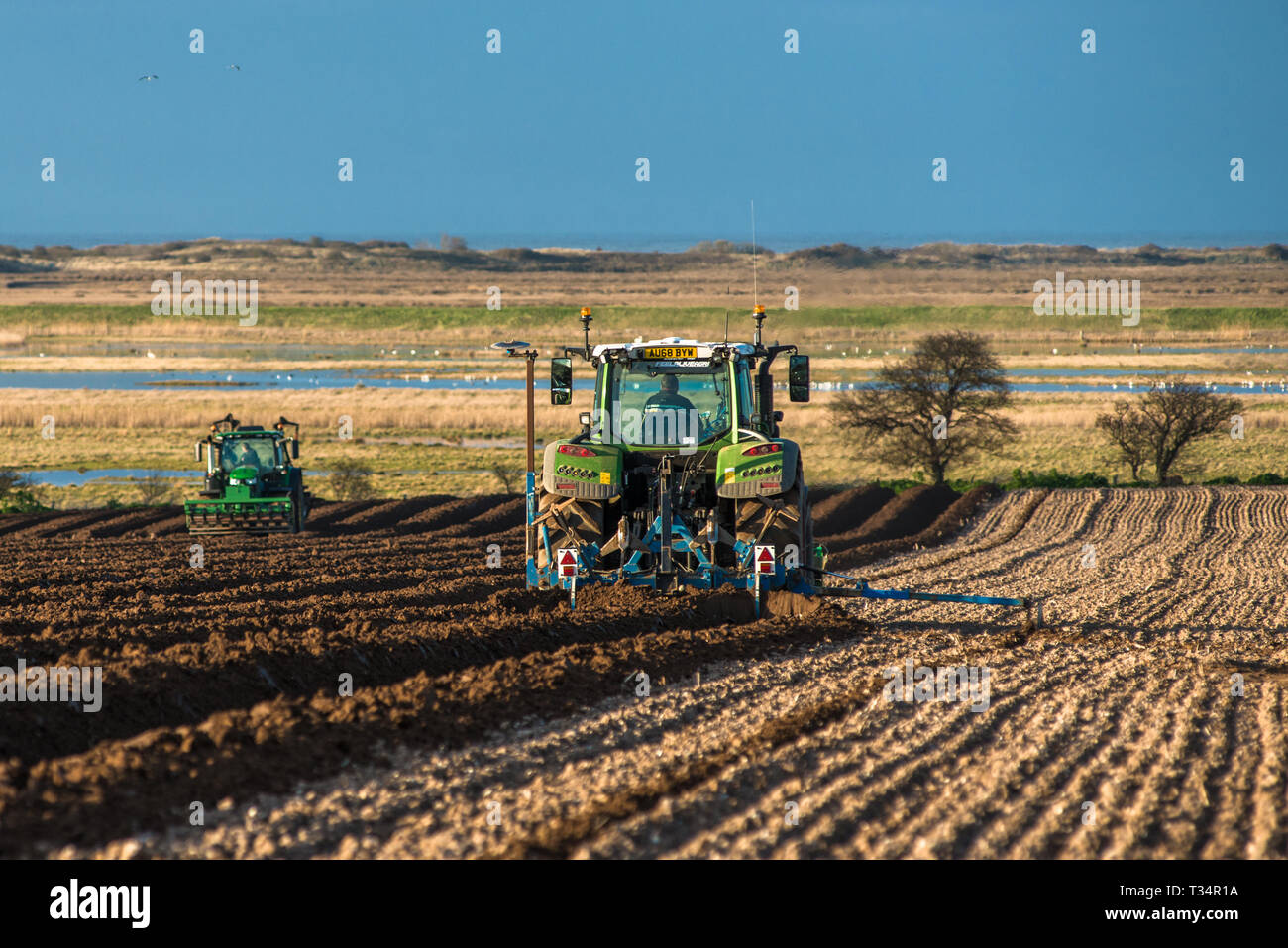 Tractors carrying out deep bed shaping followed by sowing the fields in ...