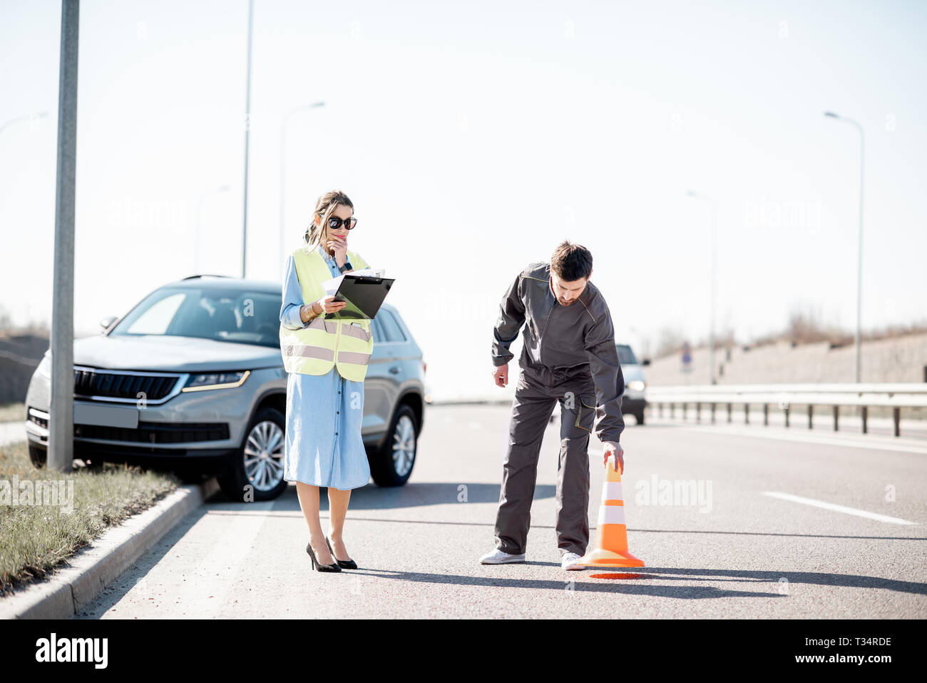 Woman and road assistance worker during the road accident on the ...