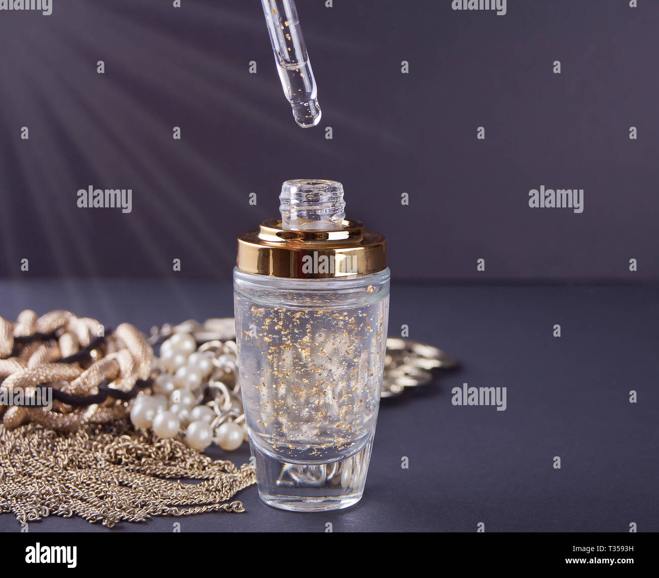 Pipette with liquid in which gold particles are visible. A drop of ...