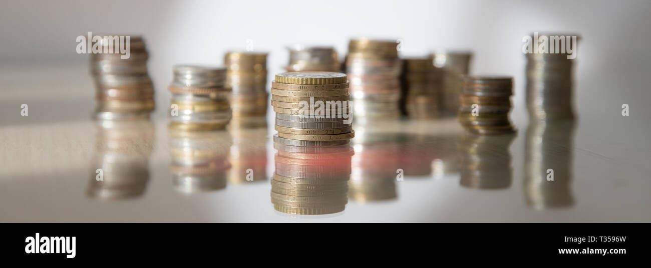 Columns of gold coins, piles of coins on working table Stock Photo - Alamy